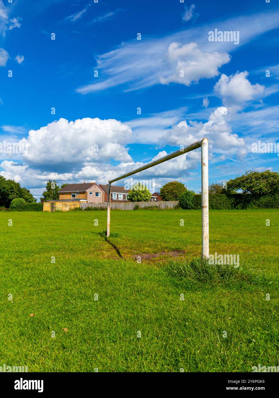 Goal posts on a football or soccer pitch in a suburban park with houses ...