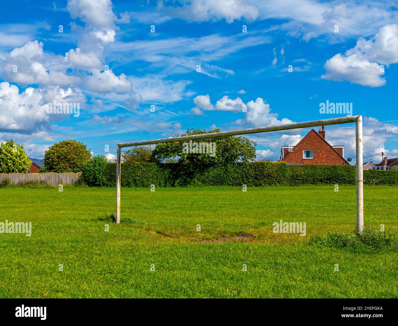 Goal posts on a football or soccer pitch in a suburban park with houses ...