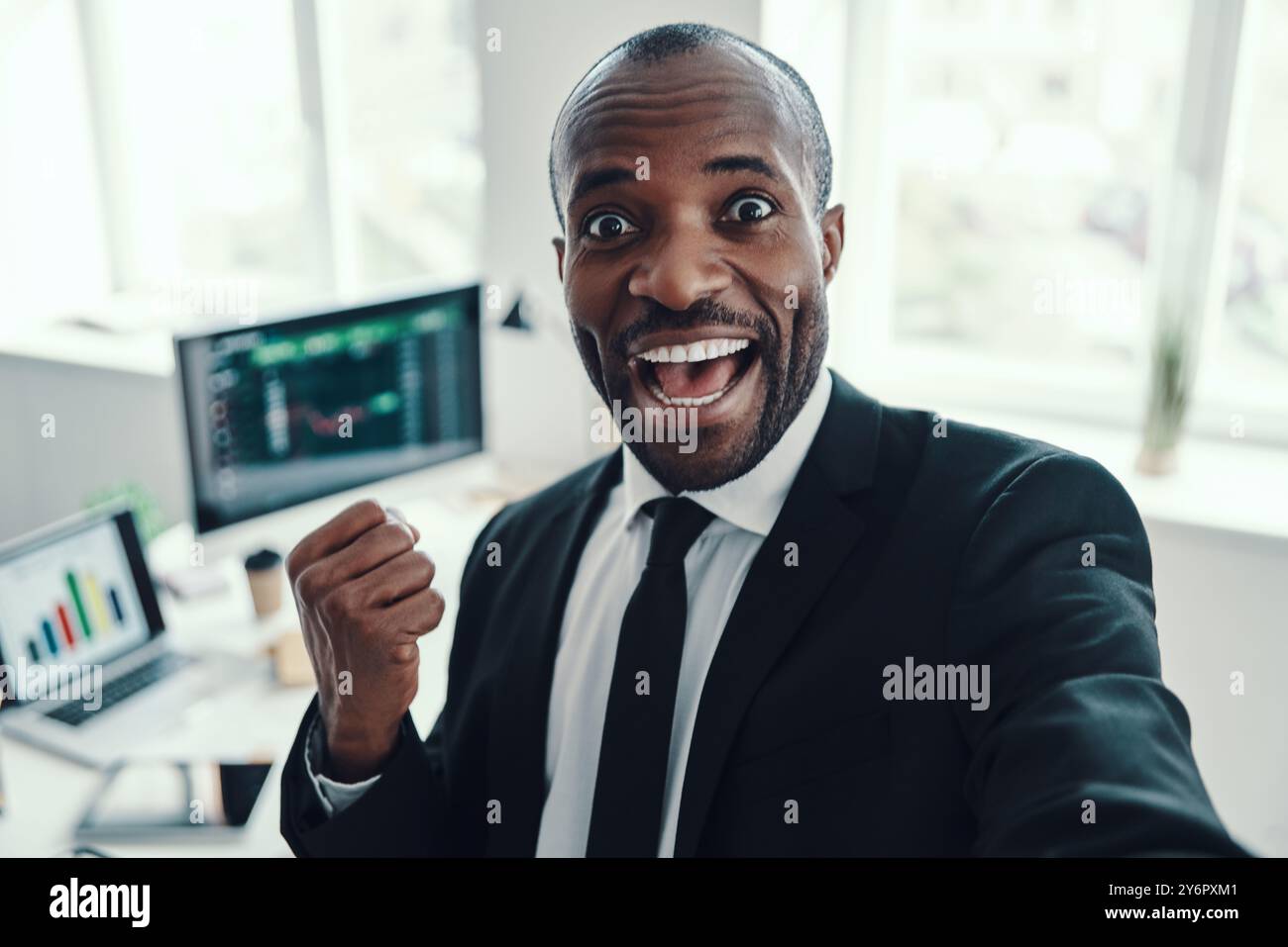 Self portrait of happy young African man in formalwear looking at ...