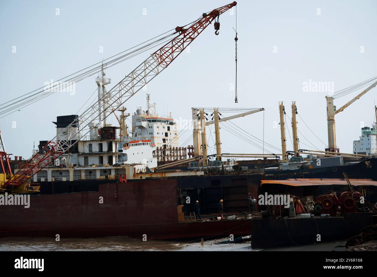 A large vessel is currently being lifted by a crane at Alang Shipyard ...