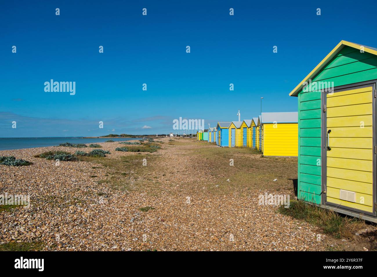 Traditional brightly coloured beach huts along the seafront at the ...