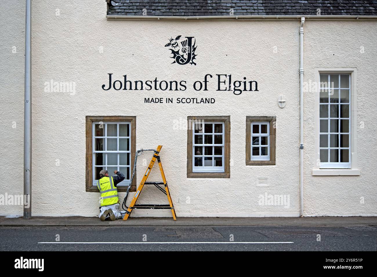 Painter painting the windows at Johnsons of Elgin Visitor Centre at ...