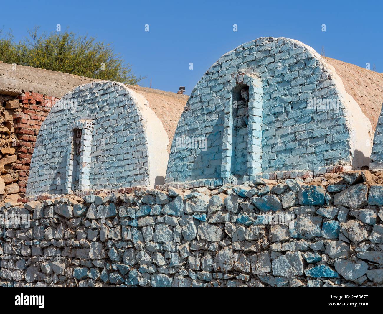 Rear facade of houses of ancient Nubian village on the hill along the Nile in Aswan, Egypt Stock ...