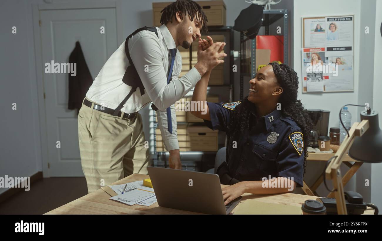 A smiling policewoman and her colleague celebrate with a high-five in ...