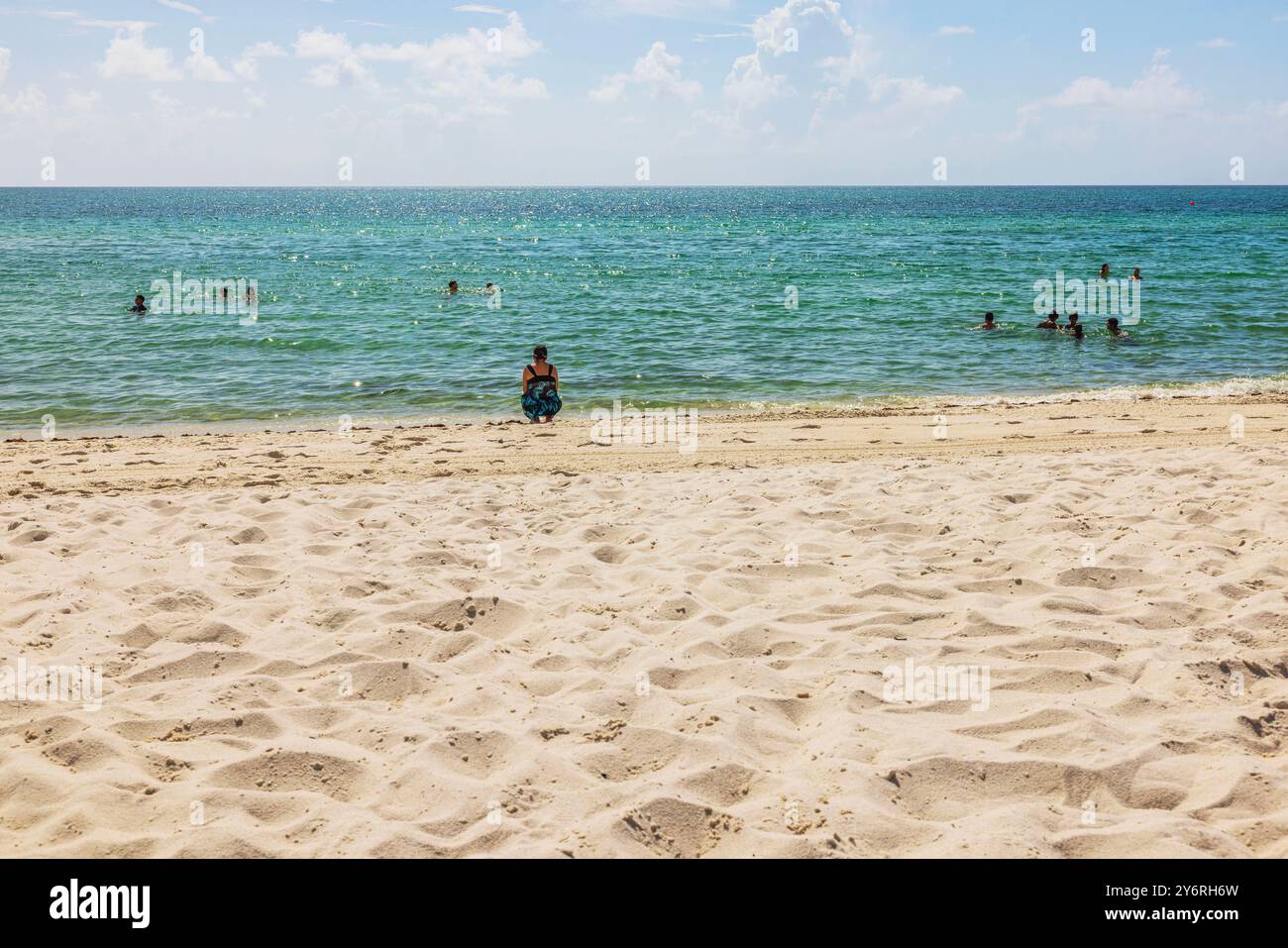 People swimming and relaxing on the beach in Miami Beach with the ...