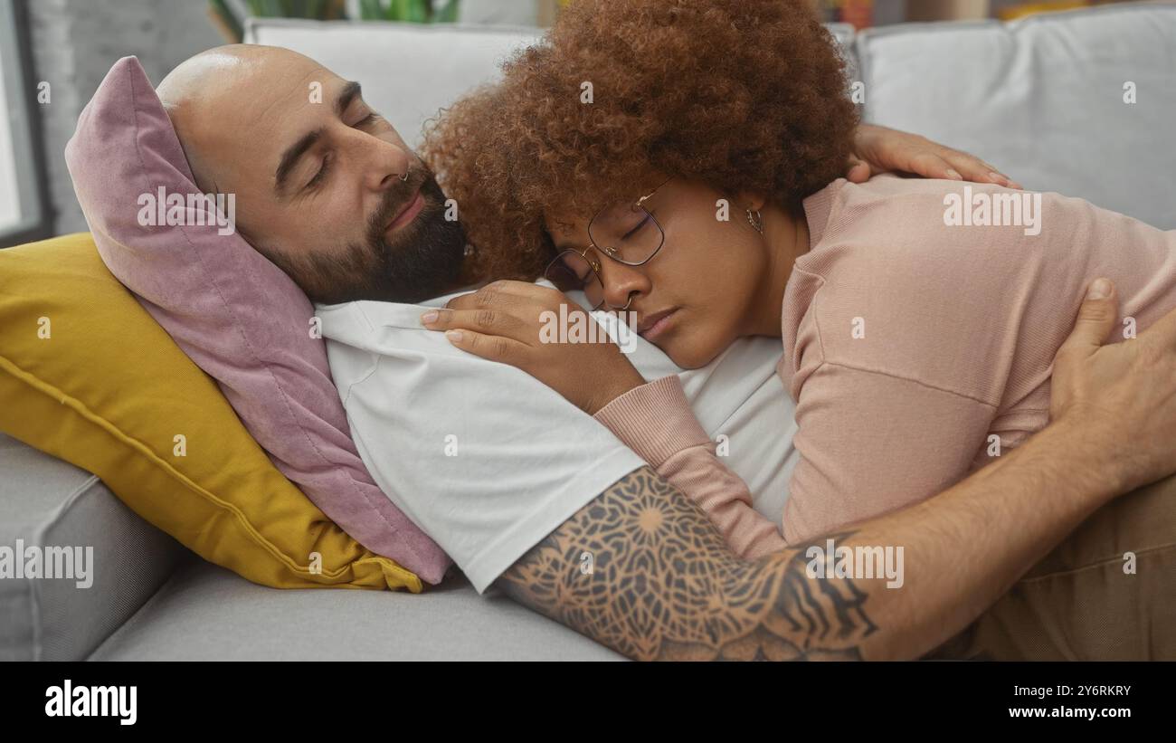 Intimate multicultural couple cuddling comfortably on a cozy sofa ...