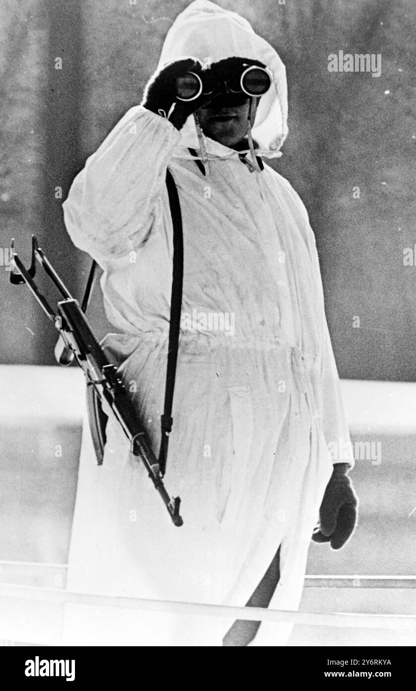 BORDER EAST GERMAN GUARD LOOKS OVER WALL WITH BINOCULARS BERLIN 8 MARCH ...