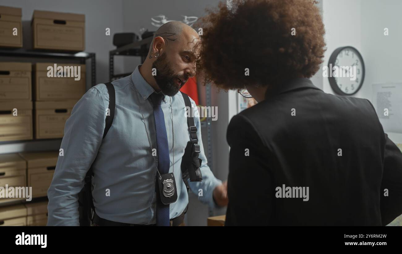 A man and a woman in professional attire converse in a police station ...