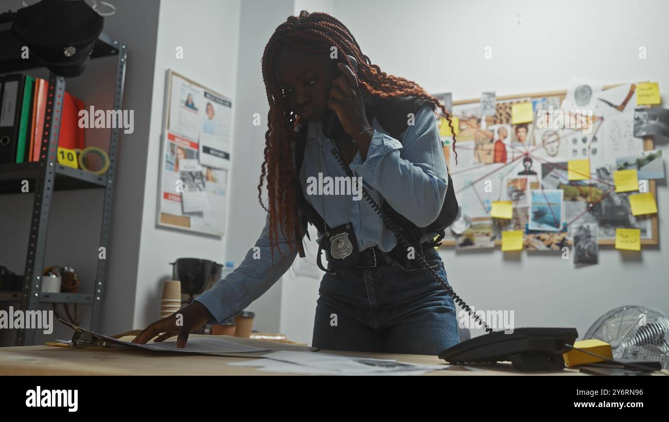 African-american female detective working in an office, analysing clues ...