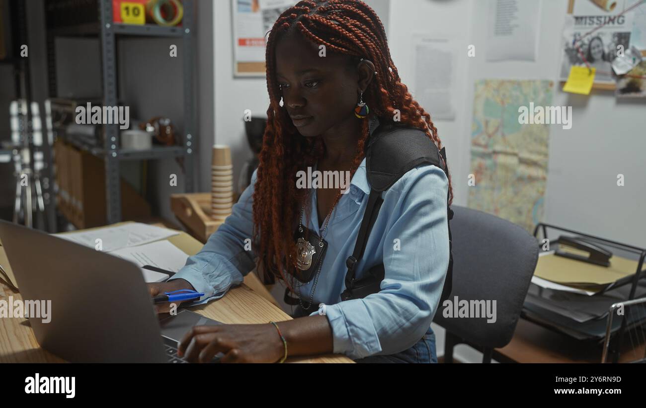 A focused african american female detective working at her desk in a ...