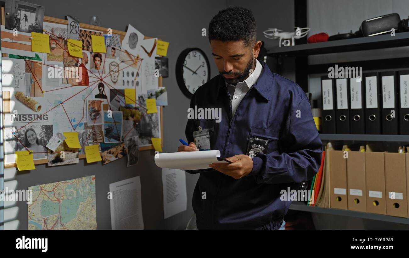 African american detective man taking notes in an office with evidence ...