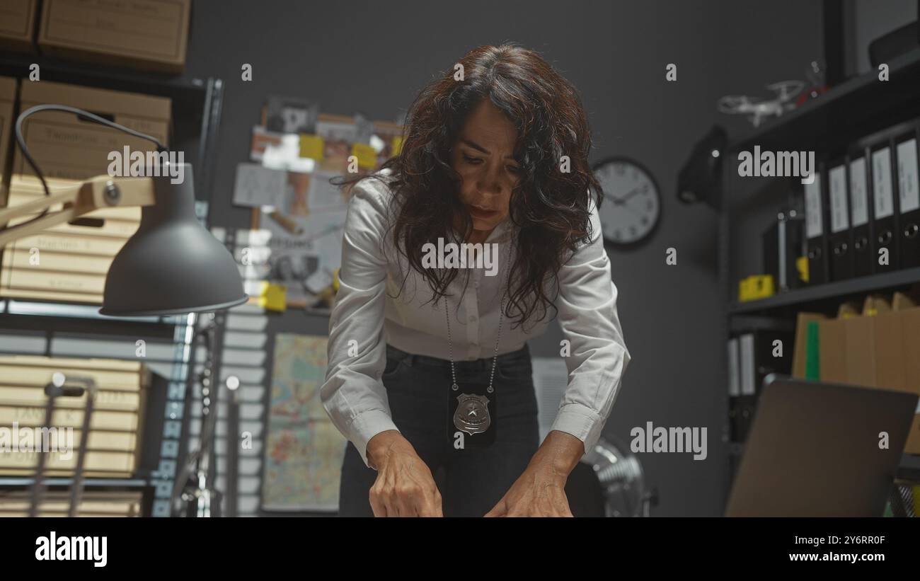 Hispanic woman detective leaning over desk in a cluttered office ...