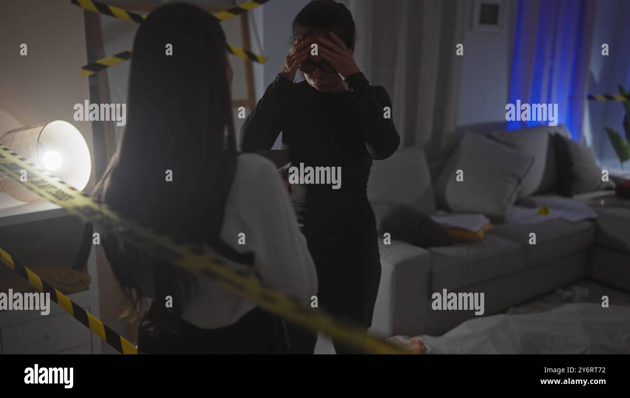 Two women investigators analyze a distressing indoor crime scene with ...