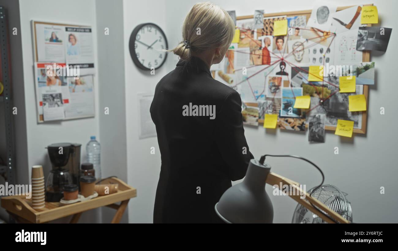A young woman detective analyzes clues on an evidence board in a police ...