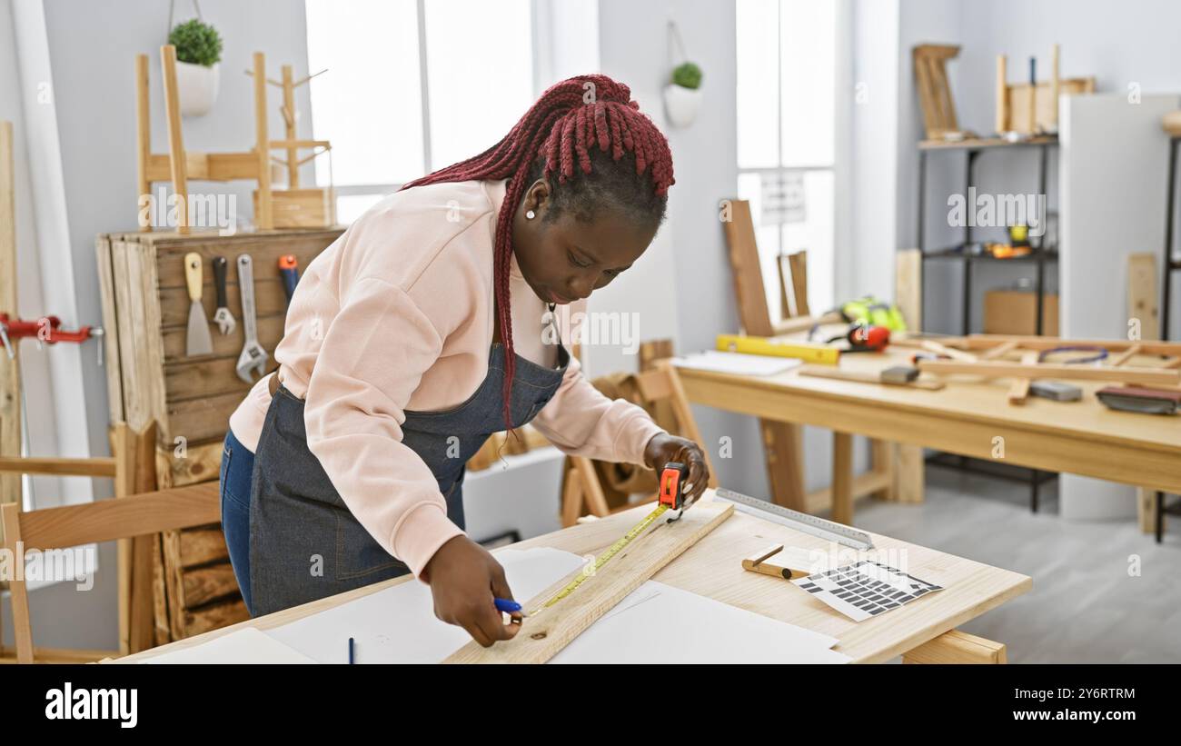 African american woman with braids working in a carpentry workshop ...