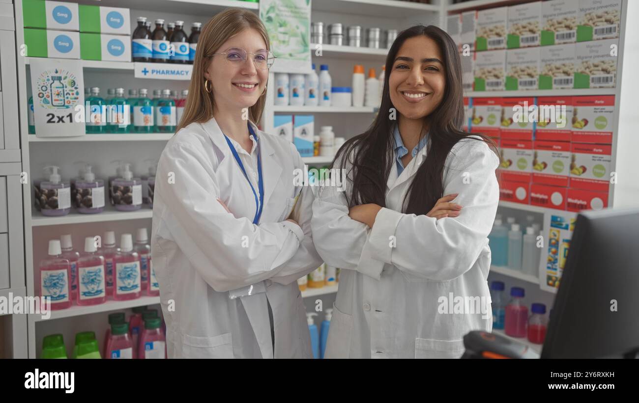 Two women pharmacists standing confidently with arms crossed in a well ...