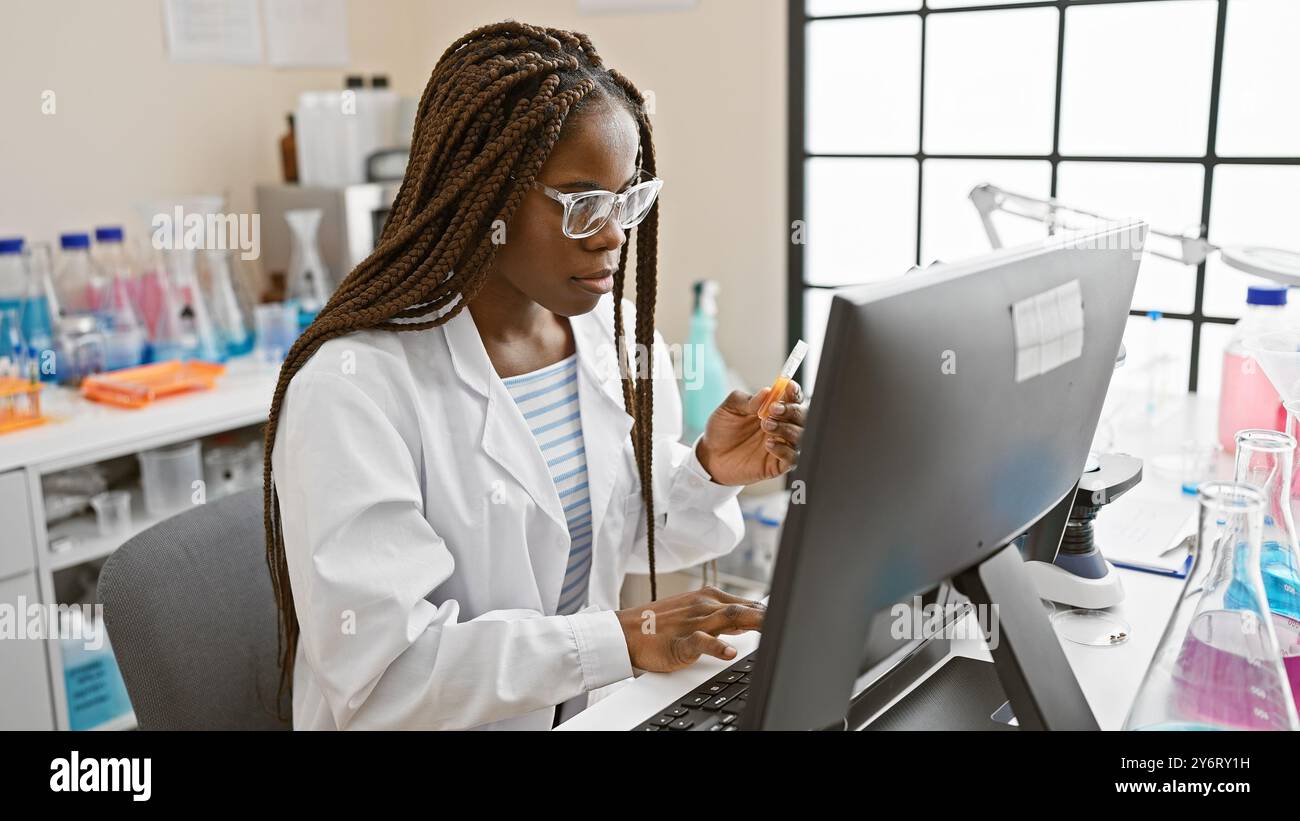 A focused african american woman with braids working in a laboratory ...