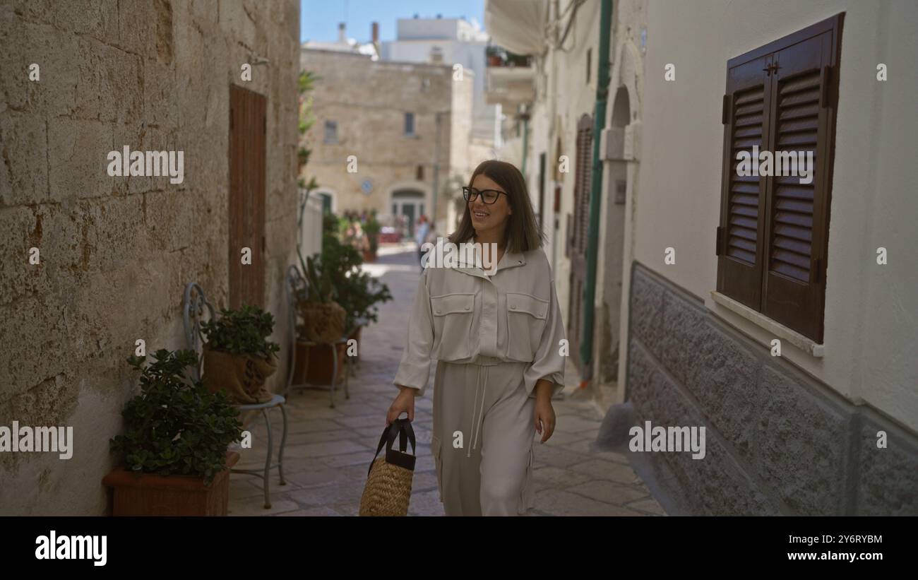A beautiful young hispanic woman walks through the charming streets of ...