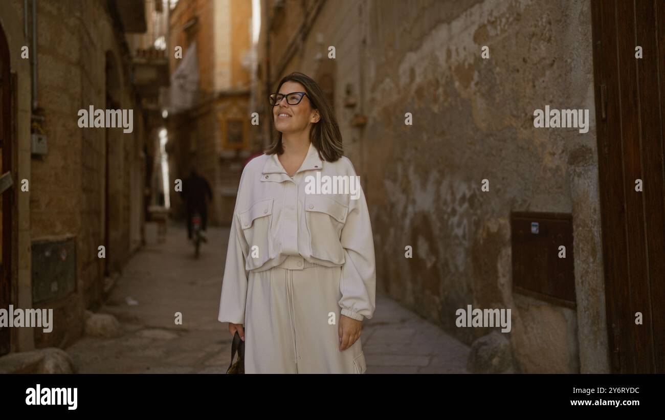 A beautiful young hispanic woman walks through the charming old town ...