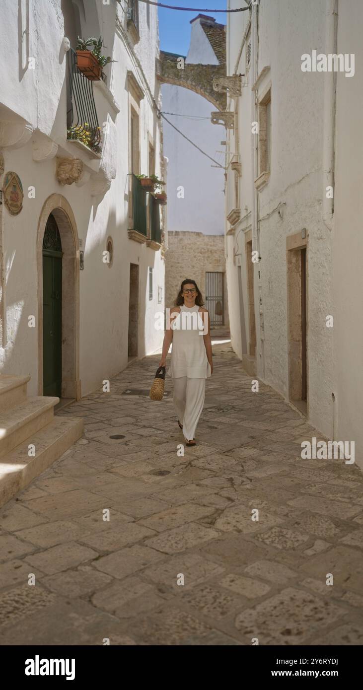 A beautiful young hispanic woman walks through the charming old streets ...