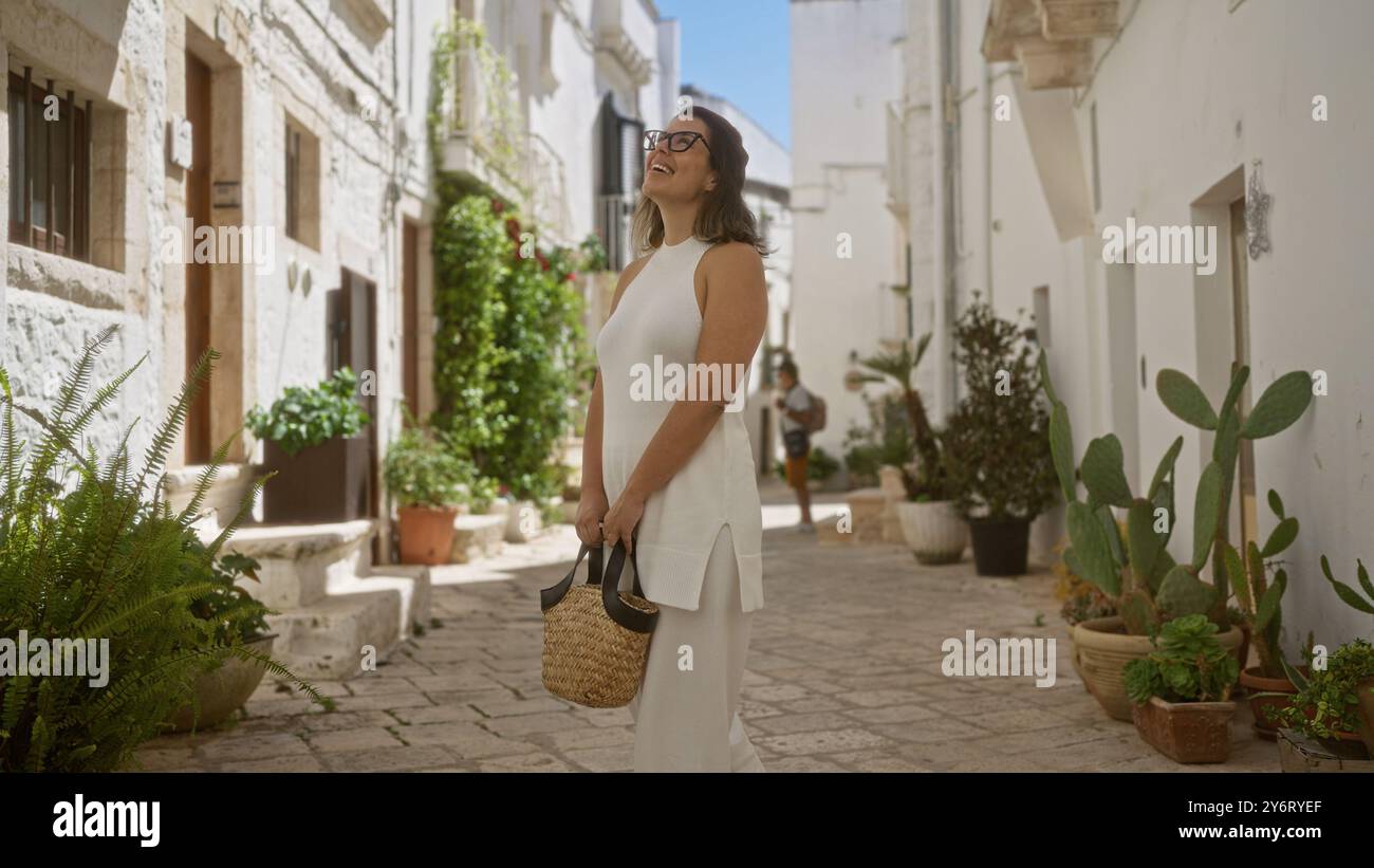 A beautiful young hispanic woman strolls through the charming old town ...