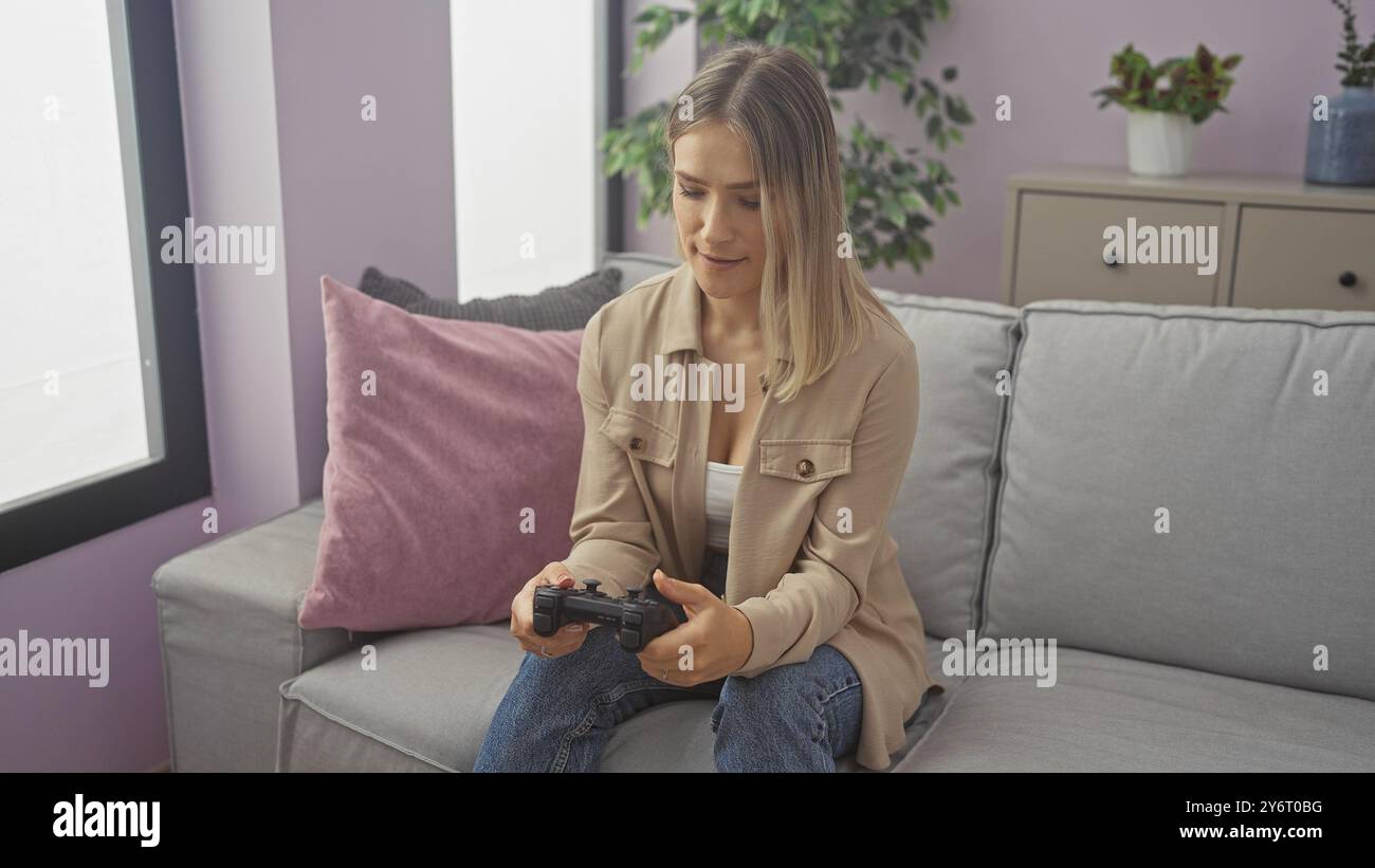 A young, beautiful blonde woman playing video games indoors in the ...