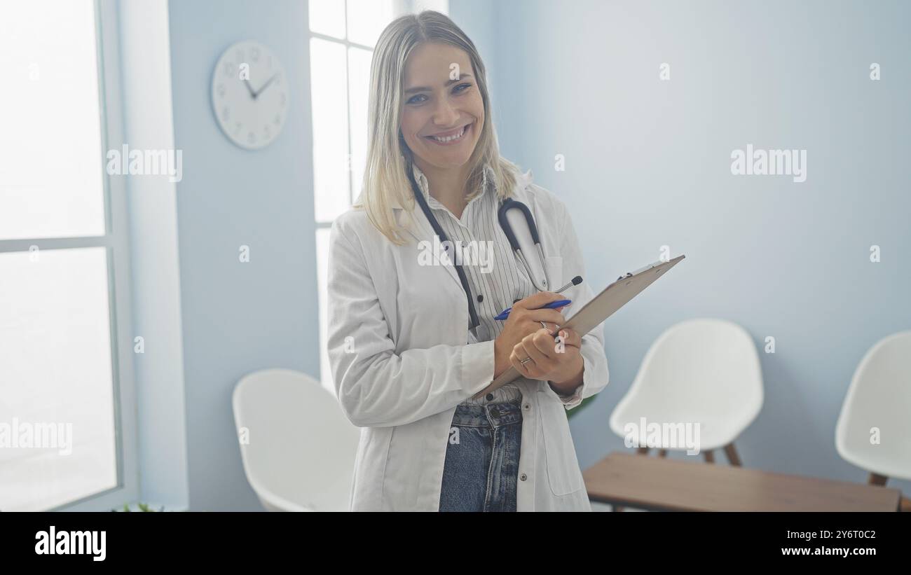 A young, beautiful, blonde female doctor stands in a clinic waiting ...