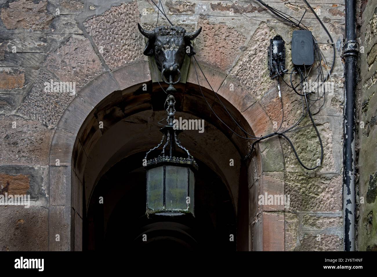 Bull's head keystone supporting an electric lamp in a courtyard off the High Street in Elgin ...