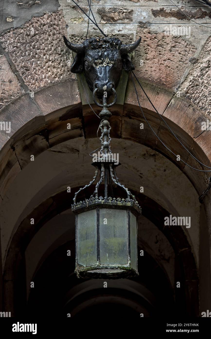 Bull's head keystone supporting an electric lamp in a courtyard off the High Street in Elgin ...