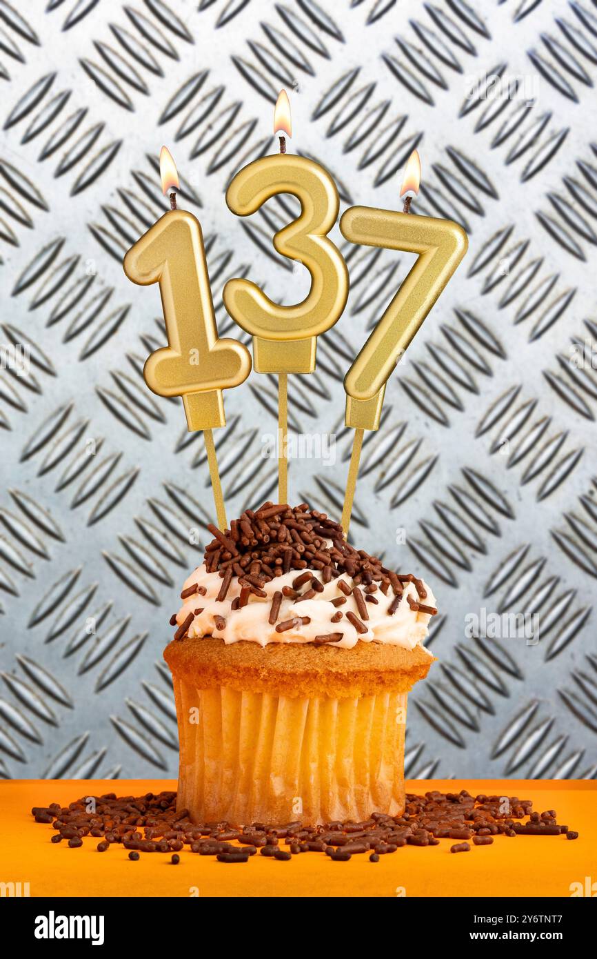 Chocolate cupcake with candle number 137 - Birthday on industrial ...
