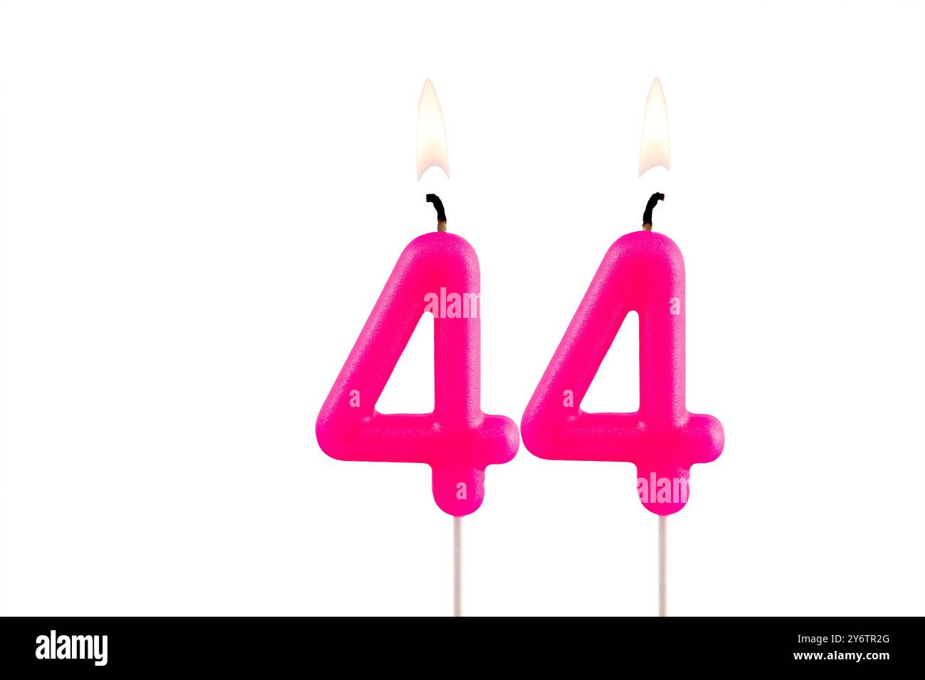 Pink number 44 birthday candle lit on white background Stock Photo - Alamy