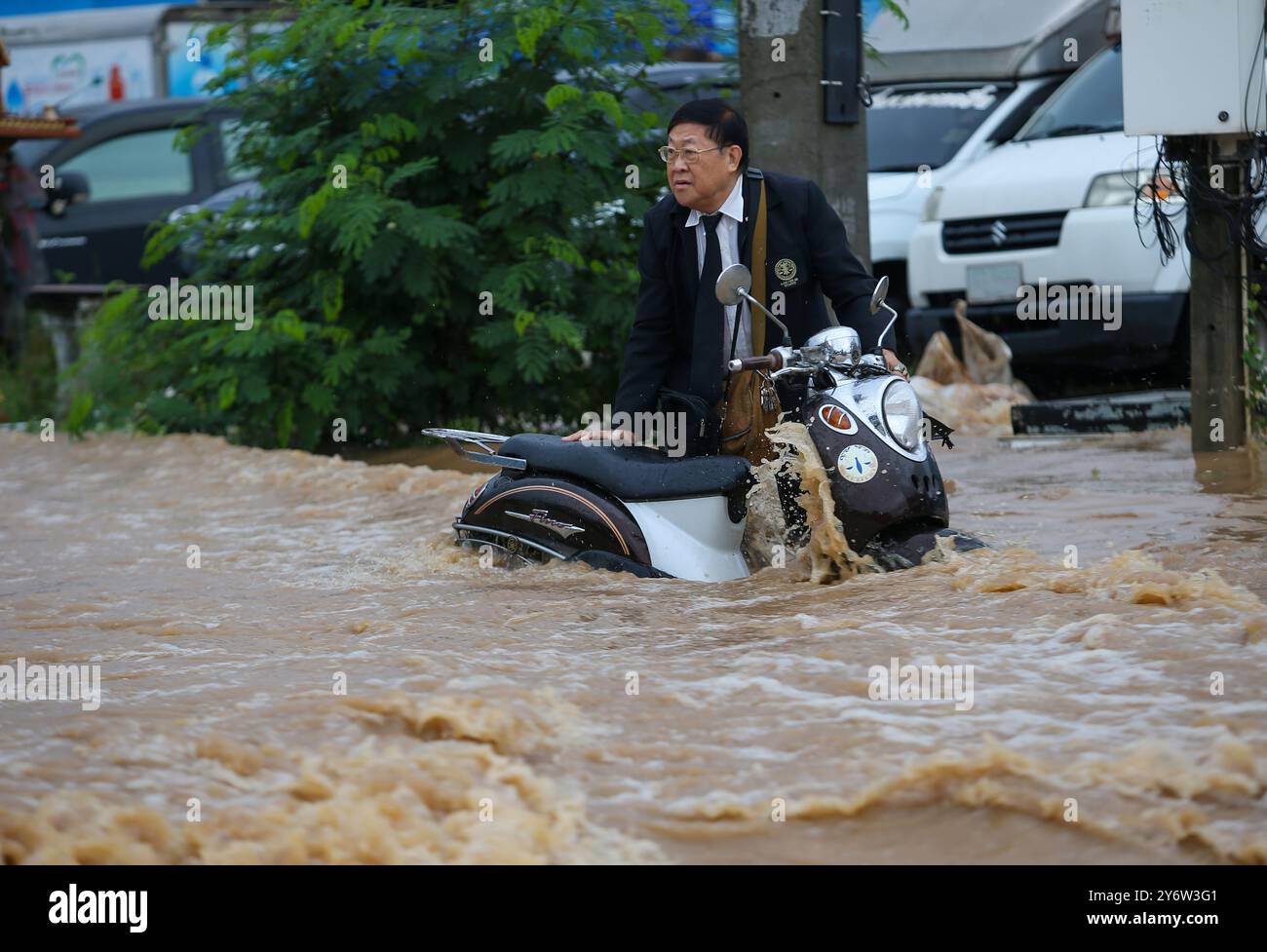 A man seen with his motorcycle on a heavily flooded street. Continuous ...