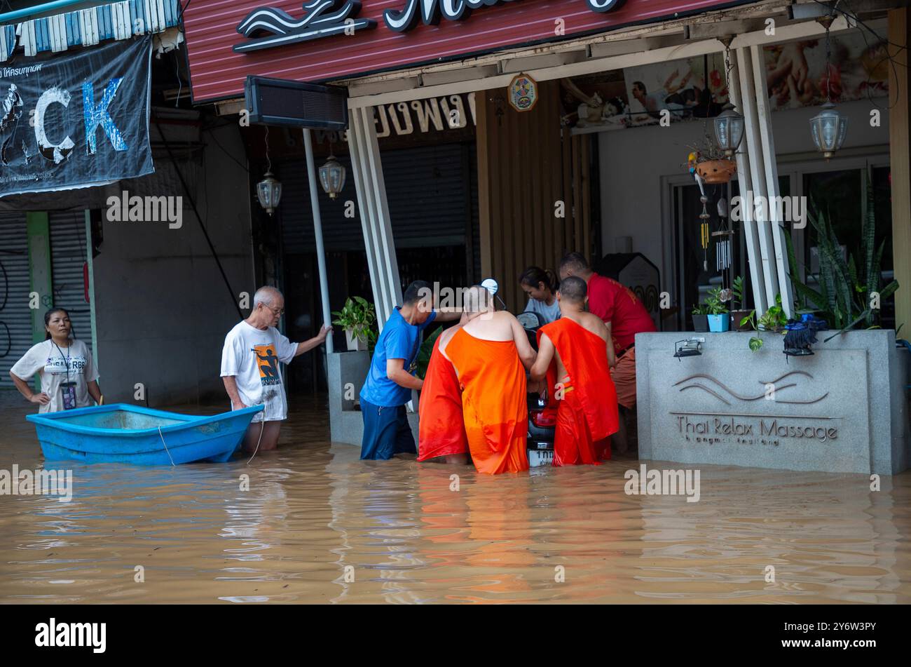 Monks and local residents are seen lifting a motorcycle out of deep ...