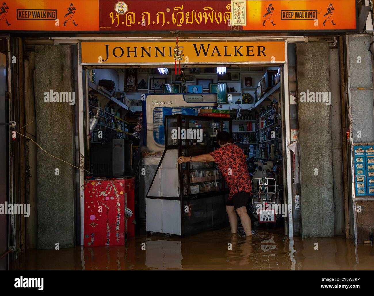 A woman seen moving items in a flooded liquor store at the Night Bazaar ...
