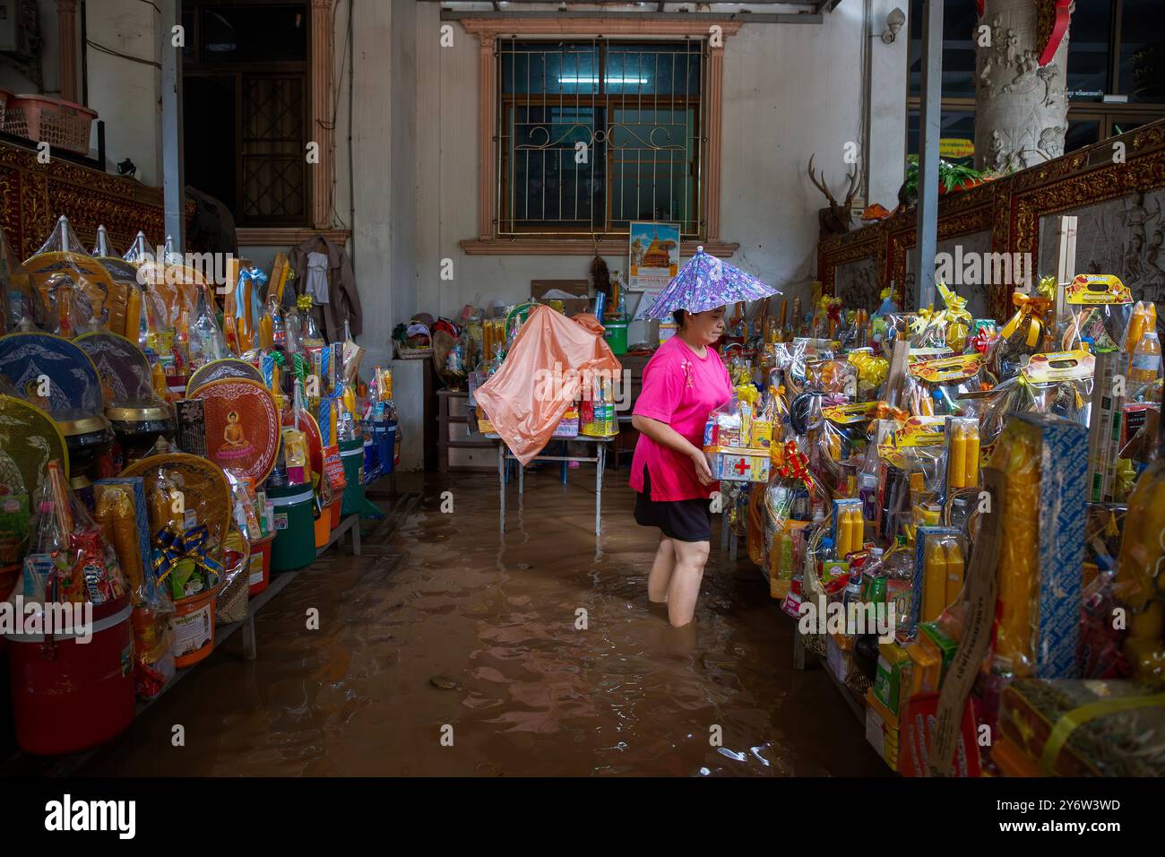 A woman seen lifting offerings for monks inside a flooded temple ...