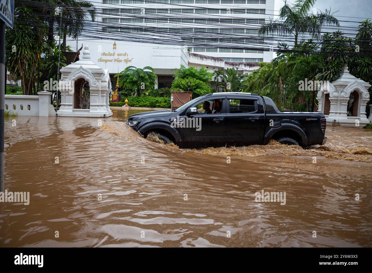 A car seen speeding through a heavily flooded street on Sridonchai Road ...