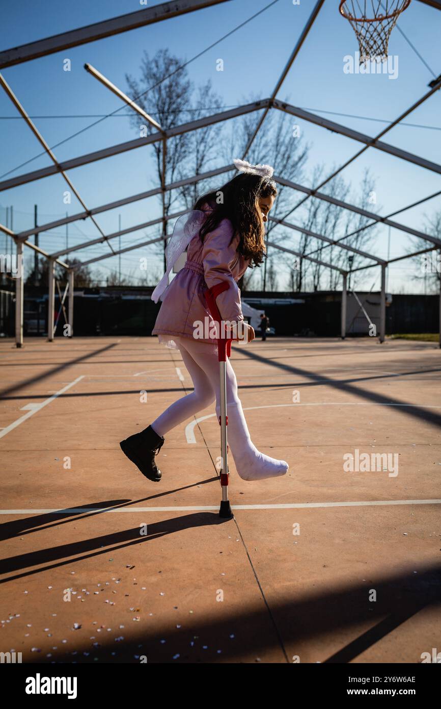 girl with leg in plaster holding crutches wearing angel carnival ...