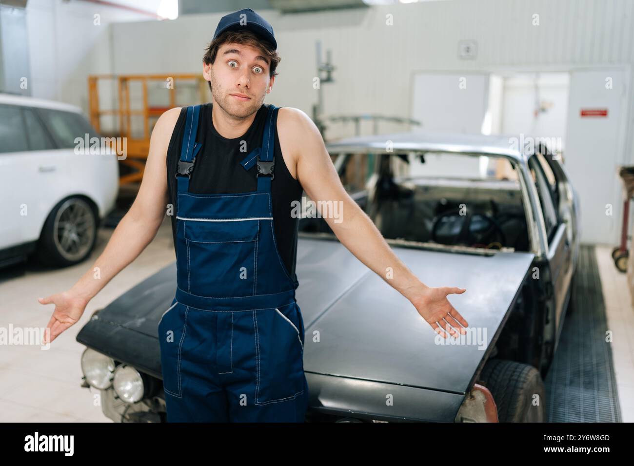 Shocked doubtful repairman in workwear clothes, trying to solve problem ...