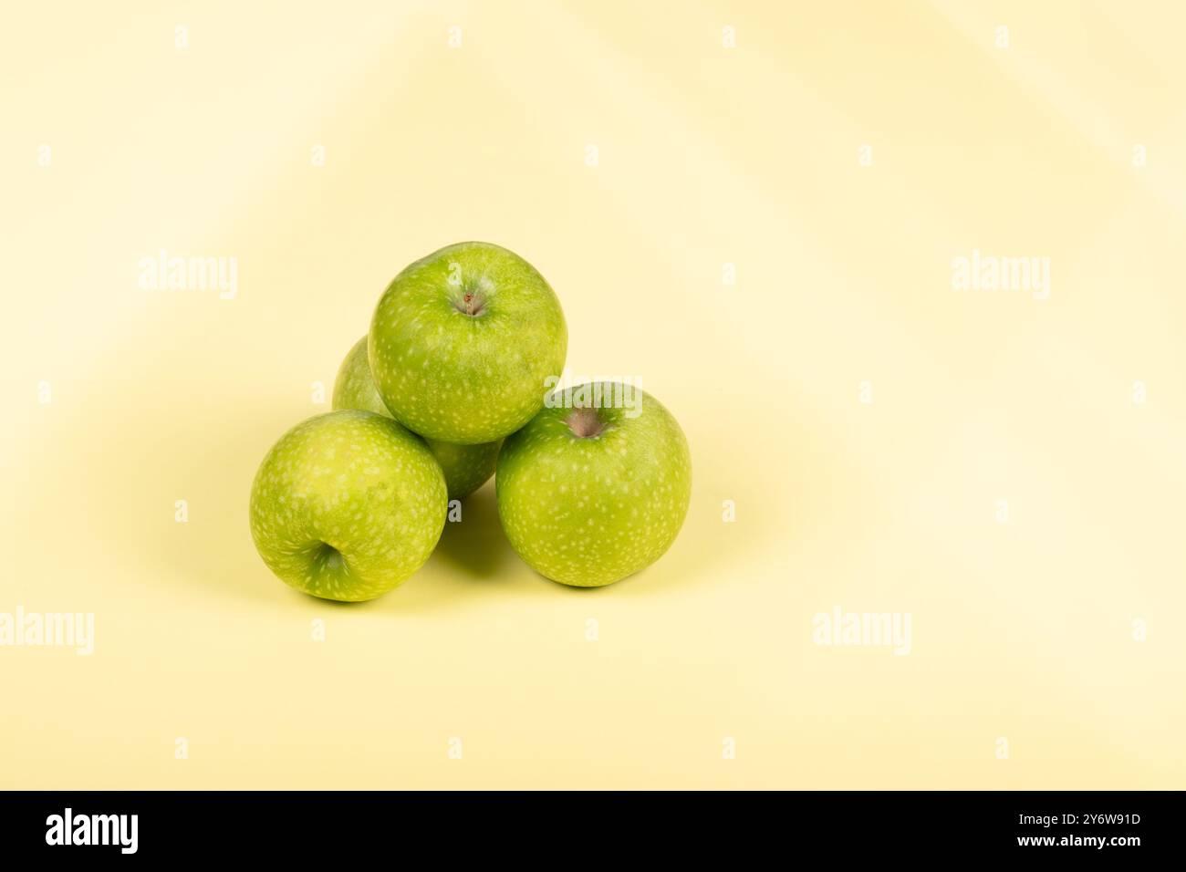 Fresh Green Apples: Trio of Crisp Granny Smith Fruits on Pale Yellow ...
