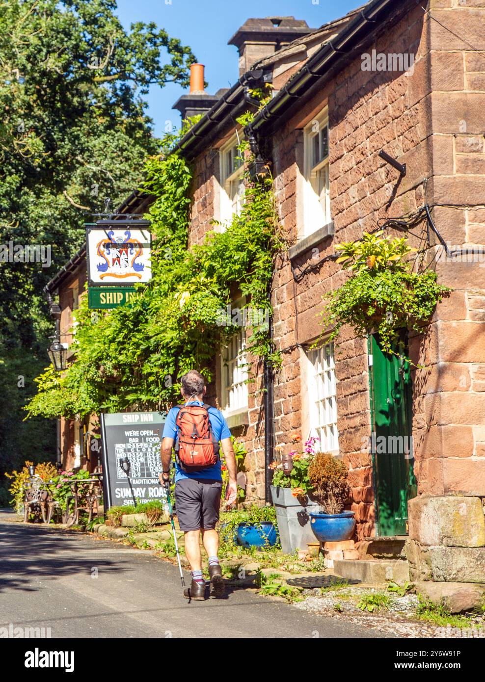 Man walking backpacking past the Ship inn a quintessential English ...
