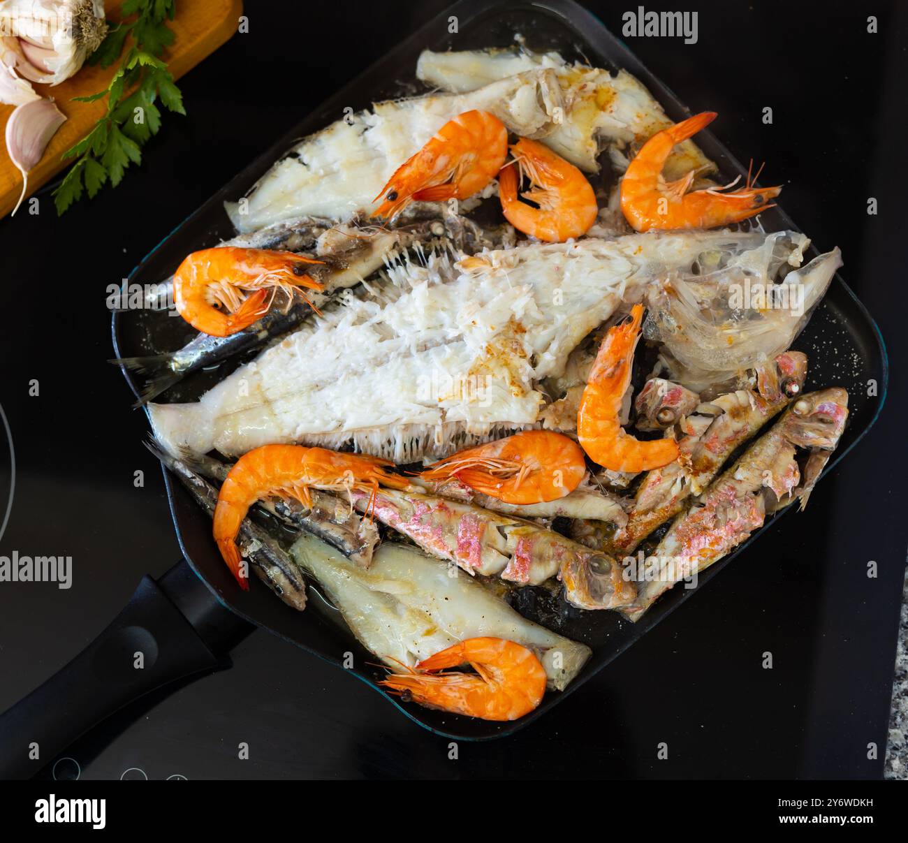 Variety of shrimp and fish sizzling in hot pan Stock Photo - Alamy