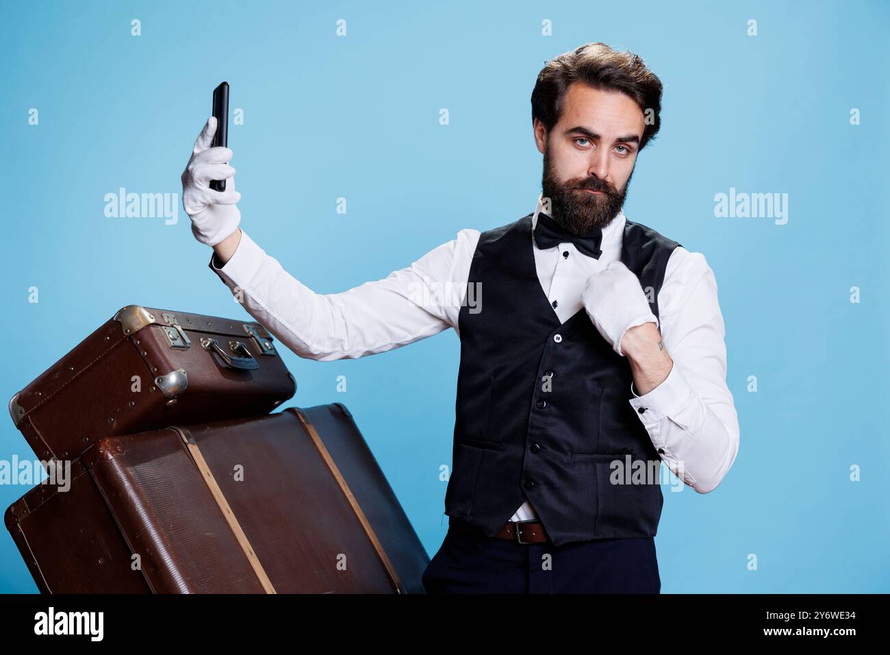 Luxurious hotel worker takes pictures while he is posing in front of ...