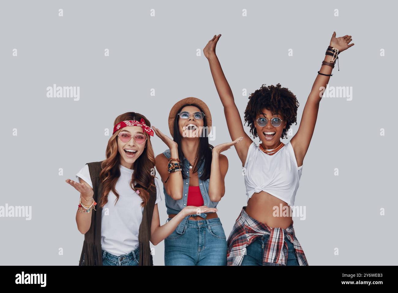 Three attractive young women cheering and smiling while standing ...