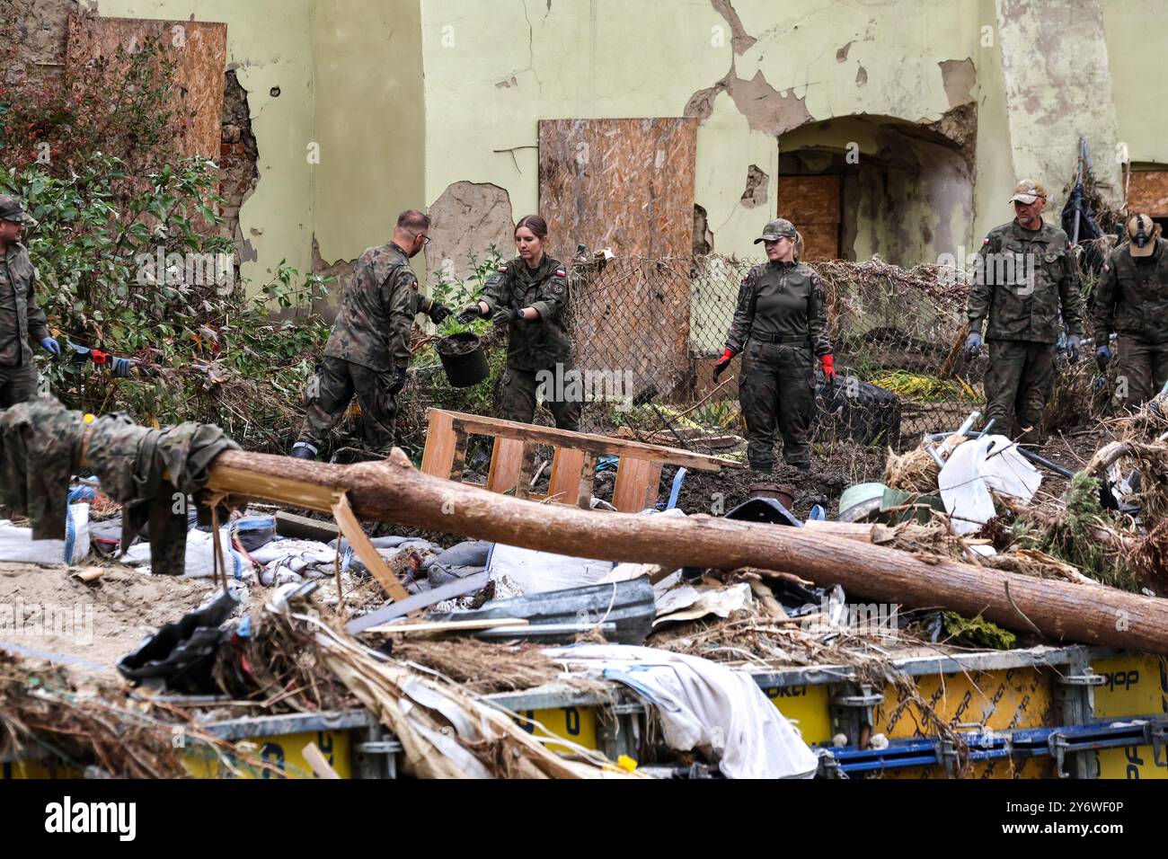 Polish army servicemen collect debris from destroyed buildings as ...