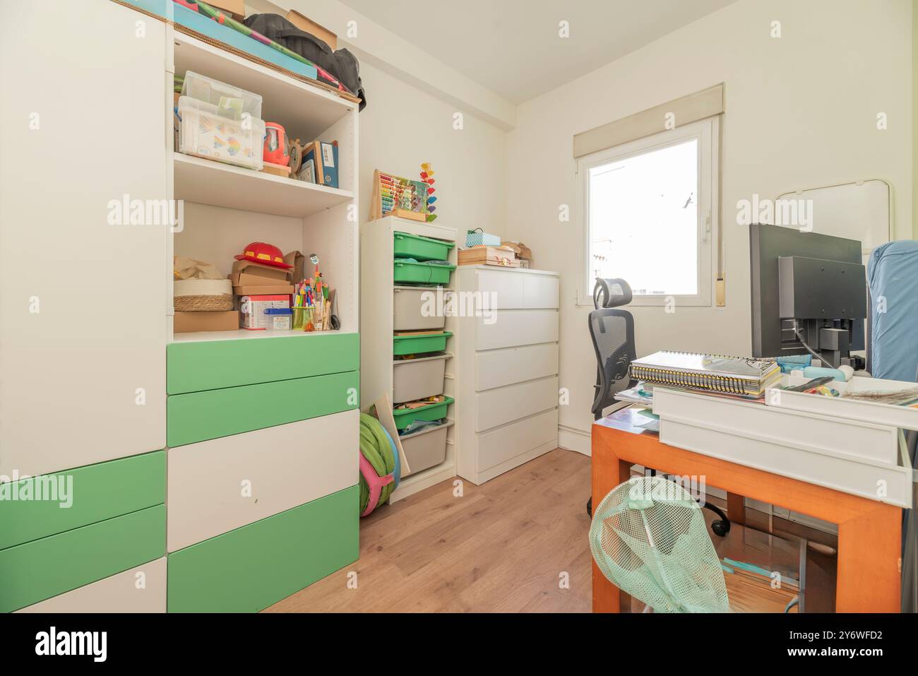 Bedroom cluttered with furniture, dressers and desk Stock Photo - Alamy