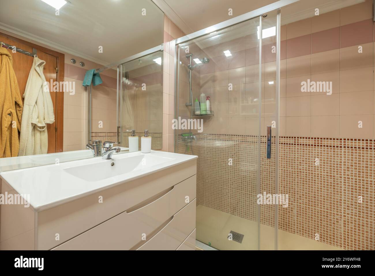 A conventional bathroom with a flat-floor shower cabin, frameless ...