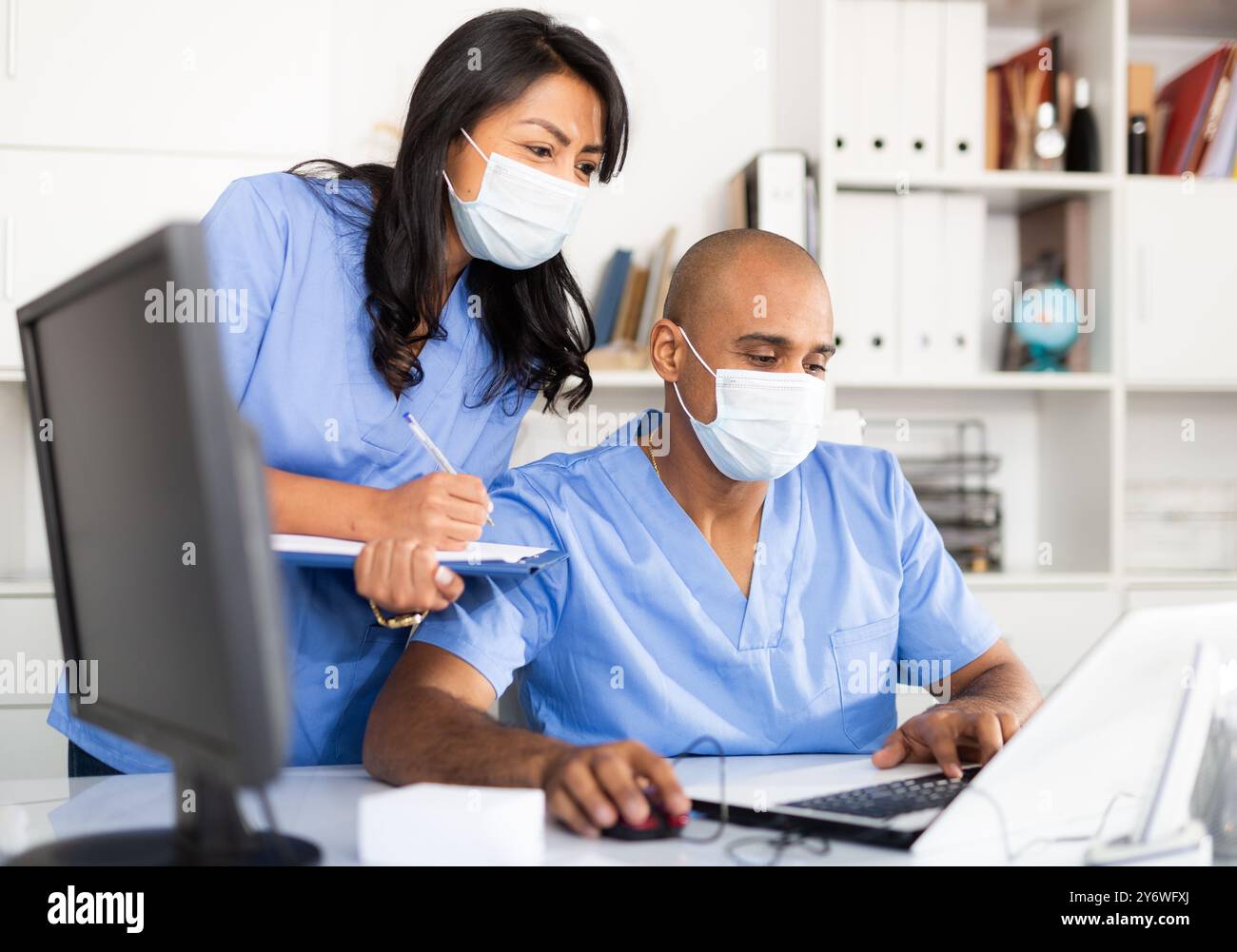 Doctor giving instructions to the secretary in office Stock Photo - Alamy