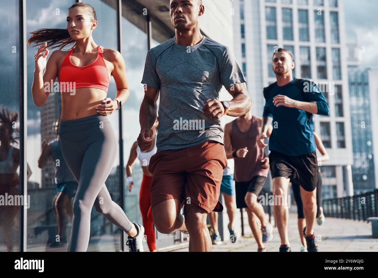 Group of people in sports clothing jogging while exercising on the ...
