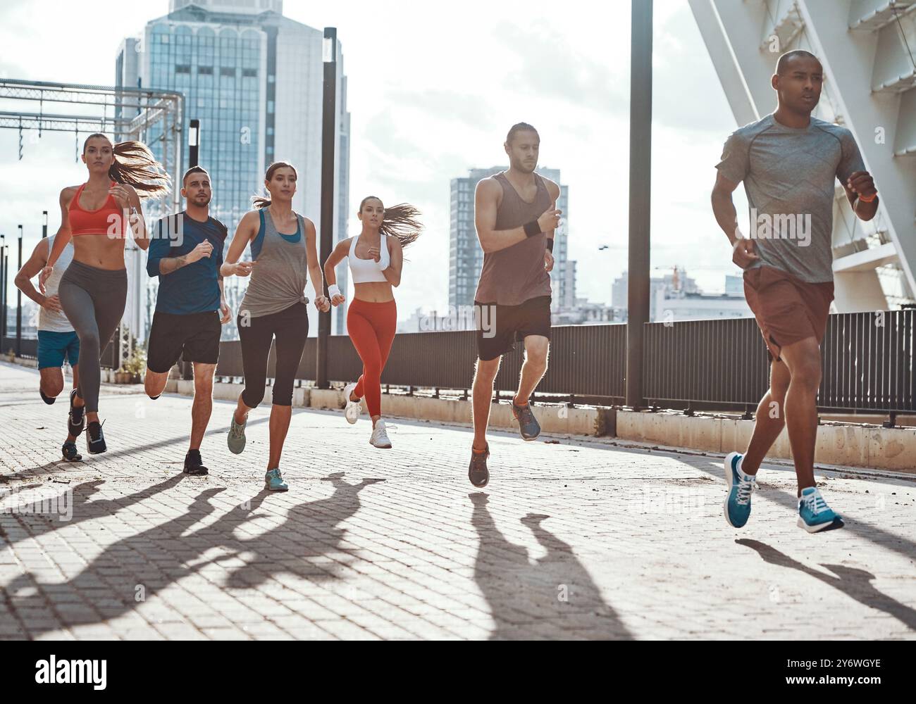 Full length of people in sports clothing jogging while exercising on ...