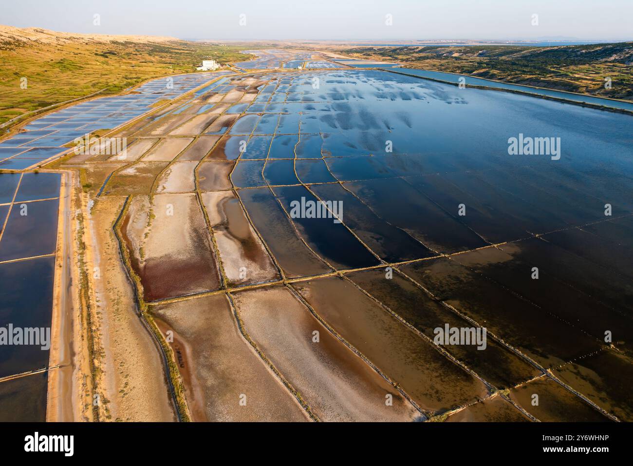 Aerial view of salt pans under the sun showcasing seawater evaporation ...